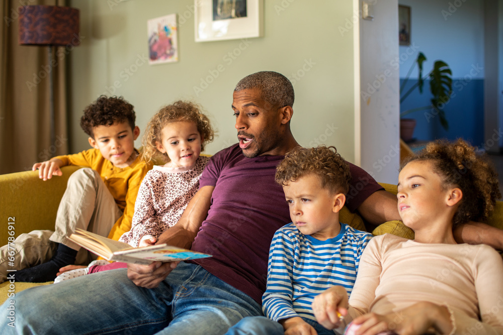 Devoted Father Reading a Storybook to His Engrossed Children at Home ...