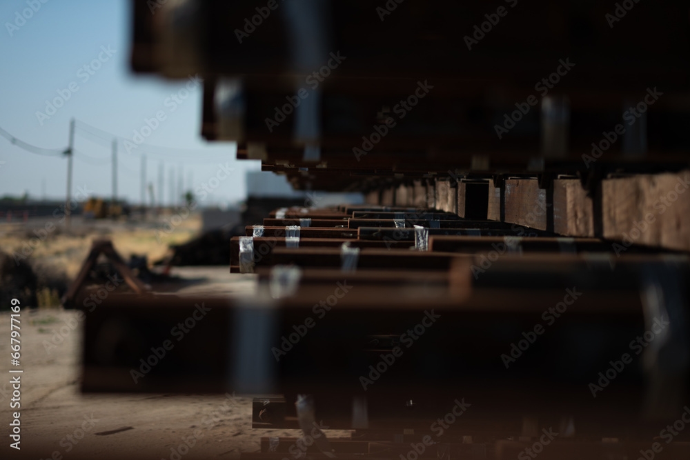 Old, rusted railroad tracks are stacked up at a storage facility along ...