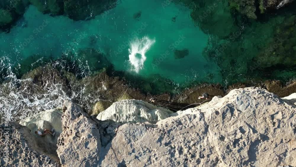 Overhead aerial view of man jumping off a cliff at the famous Sea Caves ...