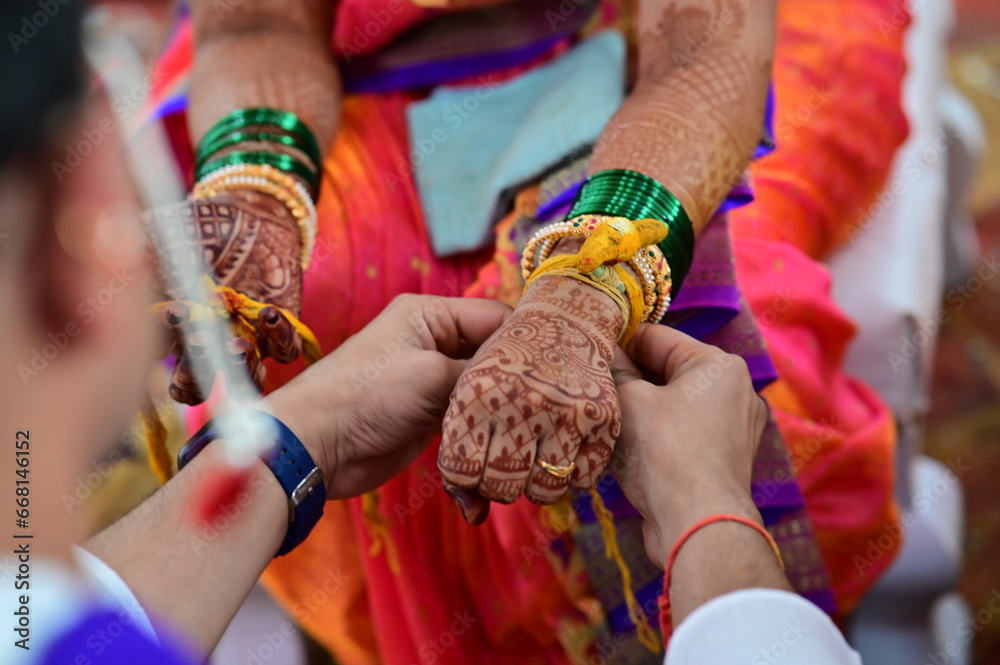 Groom Wearing Yellow Turmeric Thread on hand of bride. Hands of bride ...