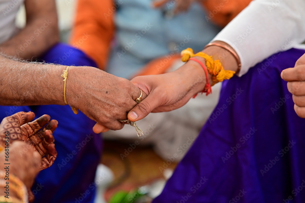 Groom hand with turmeric thread hold hand on bride's father. indian ...