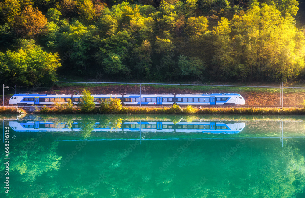 Beautiful blue modern high speed train and river in alpine mountains at ...