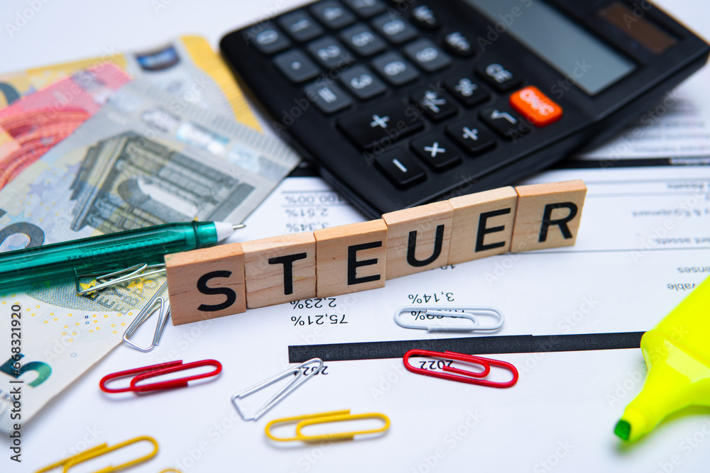 the inscription steuer, i.e. tax, next to banknotes and a calculator ...