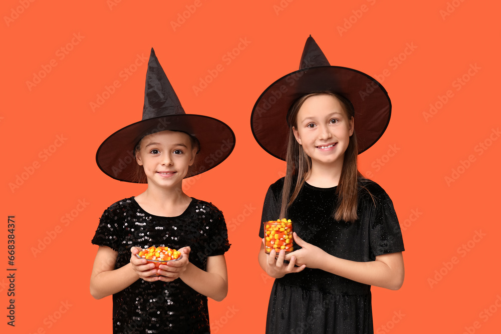 Cute little girls dressed for Halloween as witches with tasty candies ...