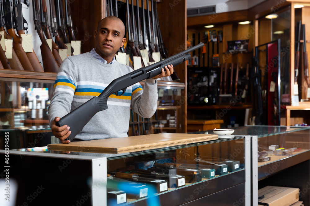 Hispanic man owner of armory shop offering modern hunting pump action ...