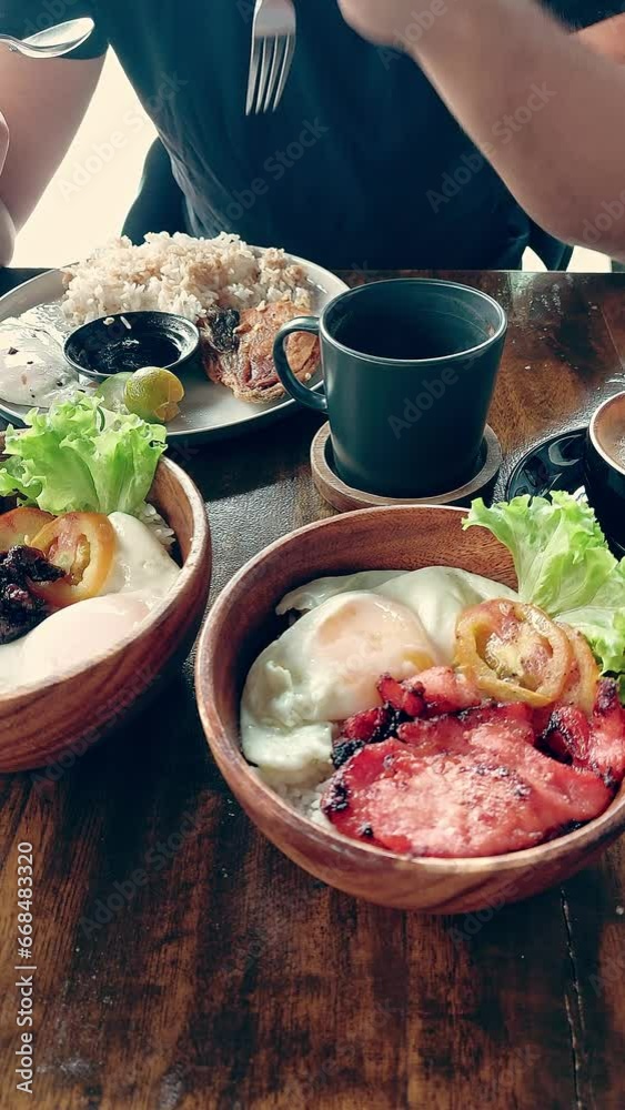 Vertical view of a tourist eating bangsilog which is a traditional ...