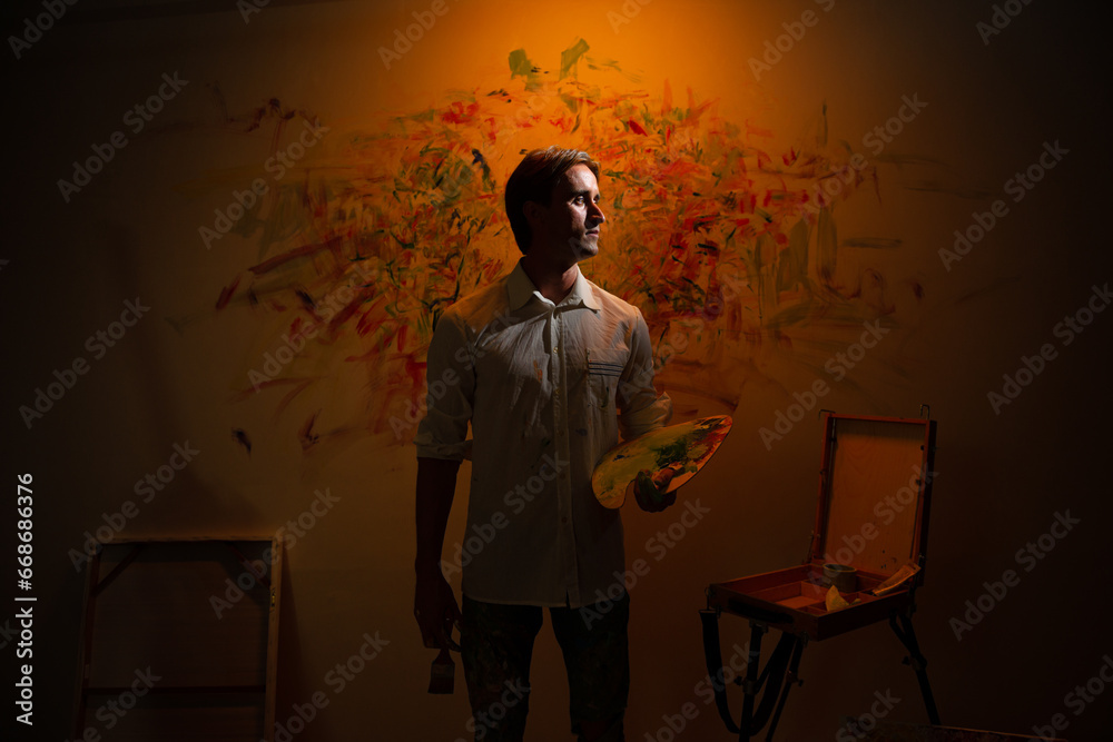 In front of the camera in art studio the artist guy very handsome ...