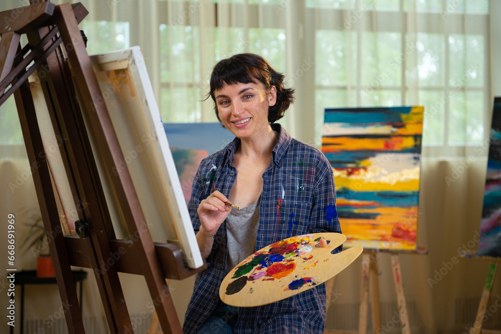 Creative young woman painter working on a new artwork for her project ...