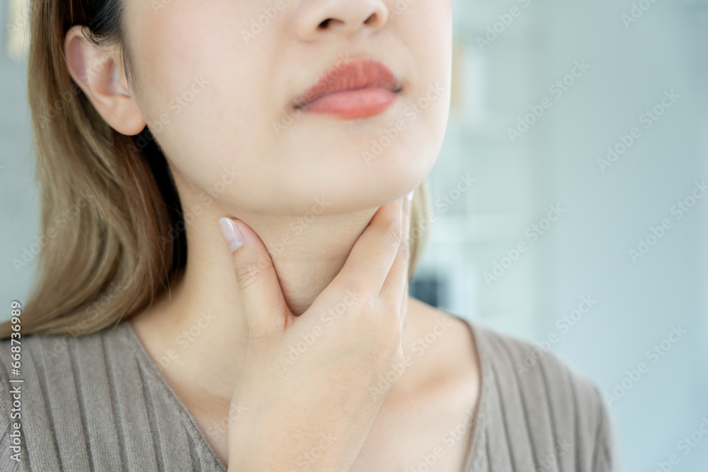 Asian woman put her hand on her neck due to a sore throat. female ...