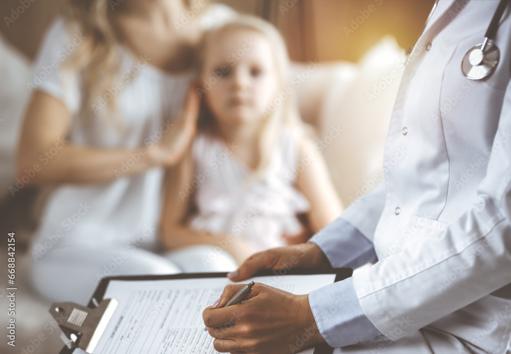 Doctor and patient. Pediatrician using clipboard while examining little ...
