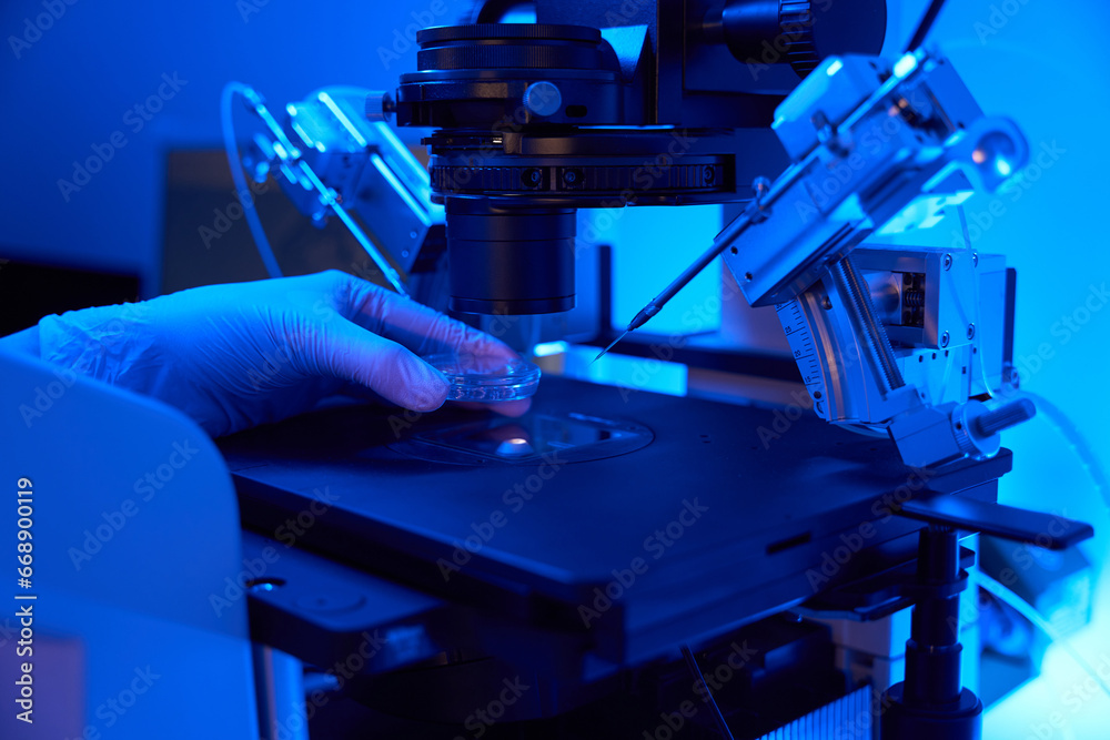 LAb researcher preparing for cell manipulation with micromanipulator in ...