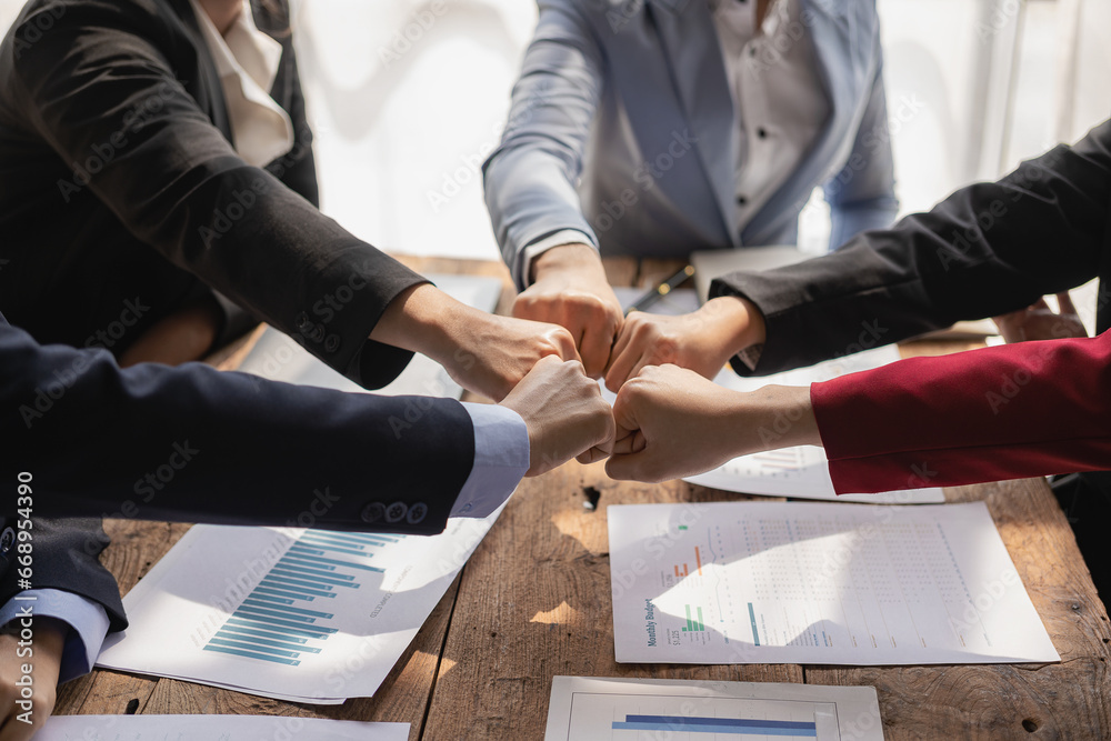 The hands of a team of businessmen joining forces celebrate the concept ...