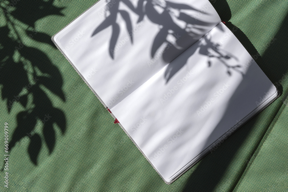 Open notebook with empty sheet mock up on green background with ...
