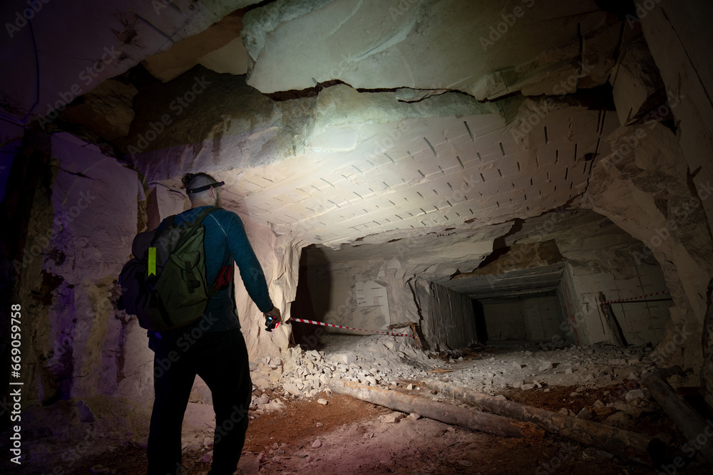 A man with powerful flashlights explores dangerous tunnels, old ...