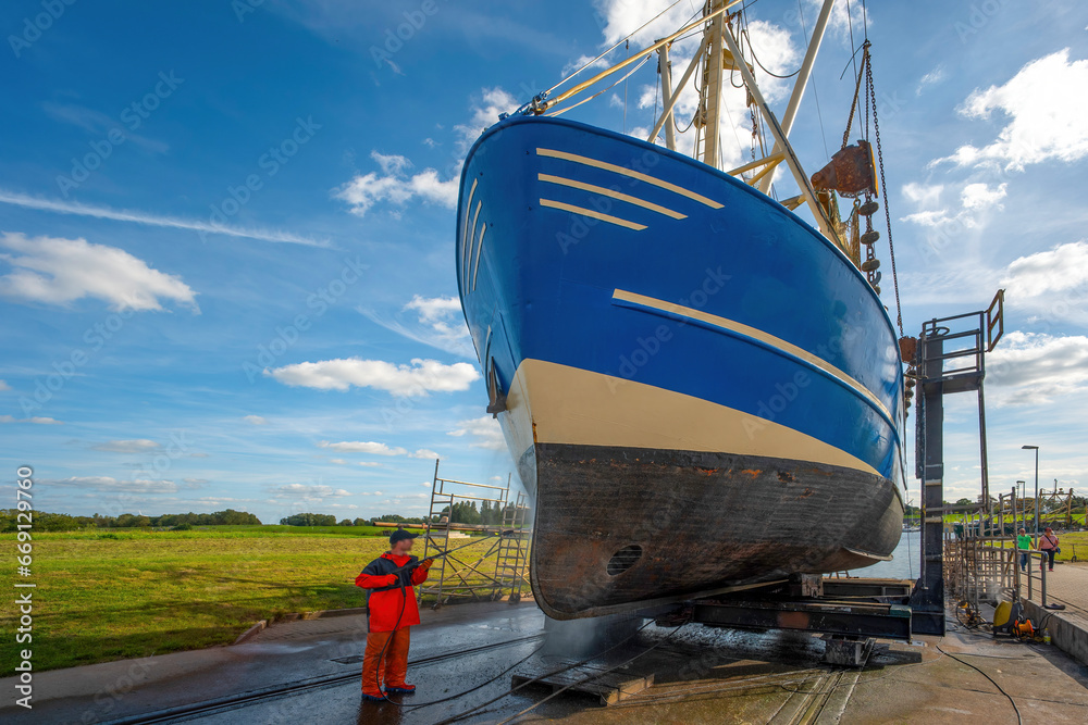cleaning a ship in the dry dock, cleaning the hull with a high-pressure ...