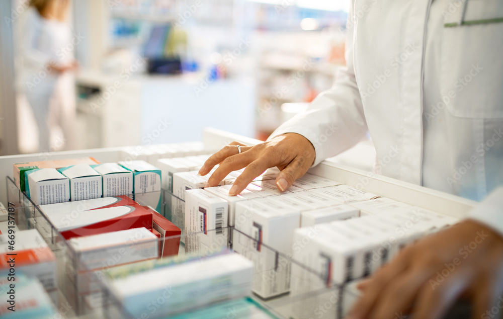 Close up of a pharmacist stacking medication in a row at the pharmacy ...