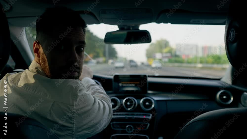 back view a man a businessman is driving a luxury car around the city a ...