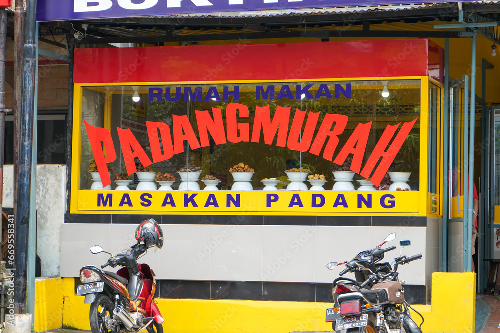 A traditional Padang restaurant in front with a glass display case ...