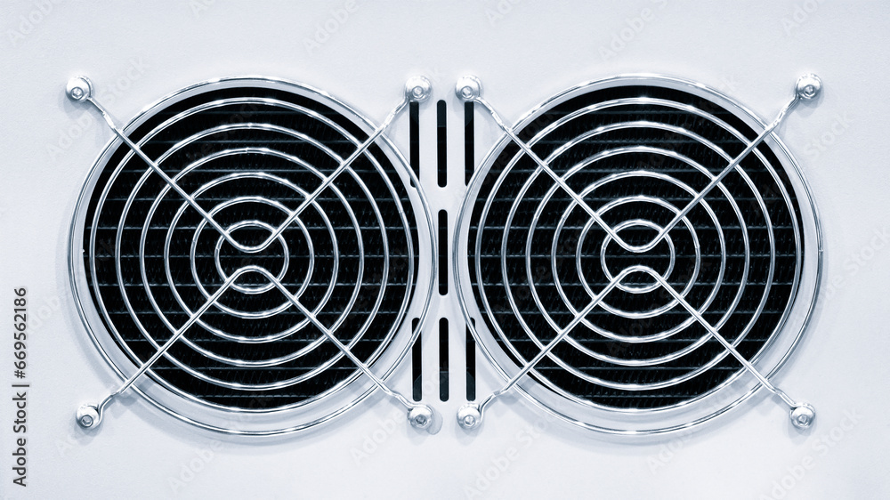 An air fan behind a metal grille installed on a modern computer AC ...