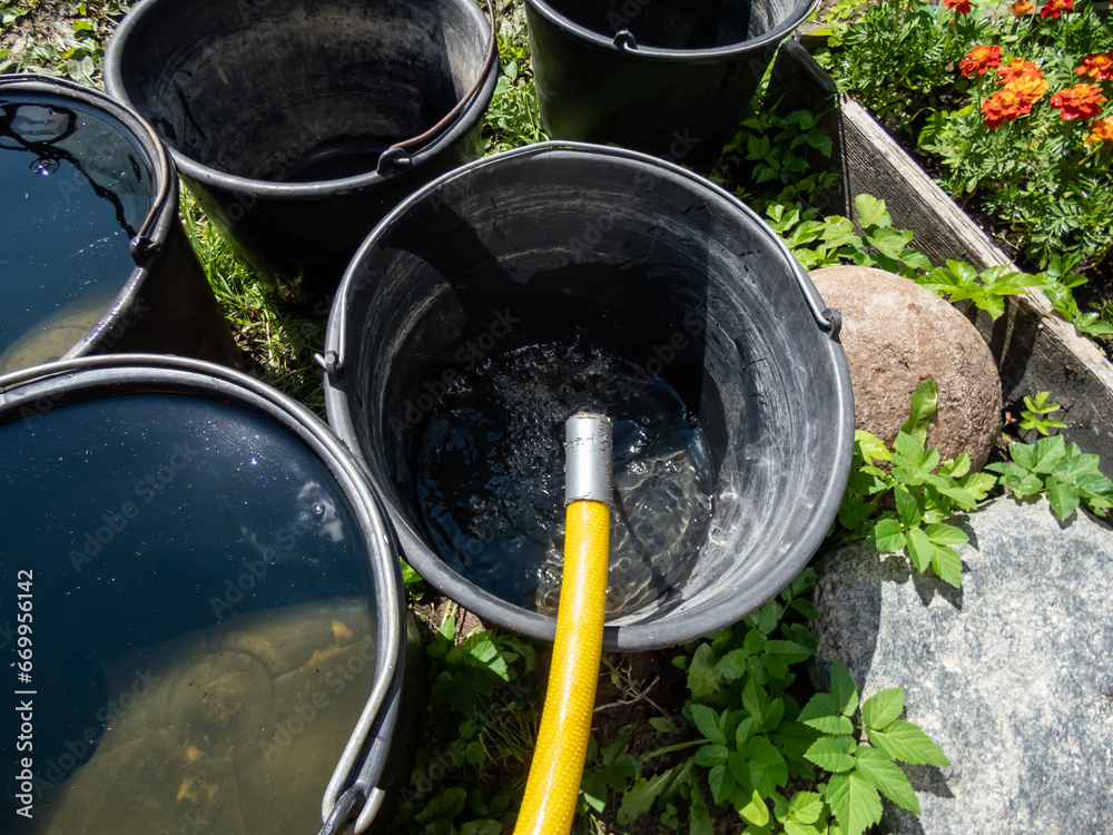 View of empty plastic buckets filling up with water pouring from a ...