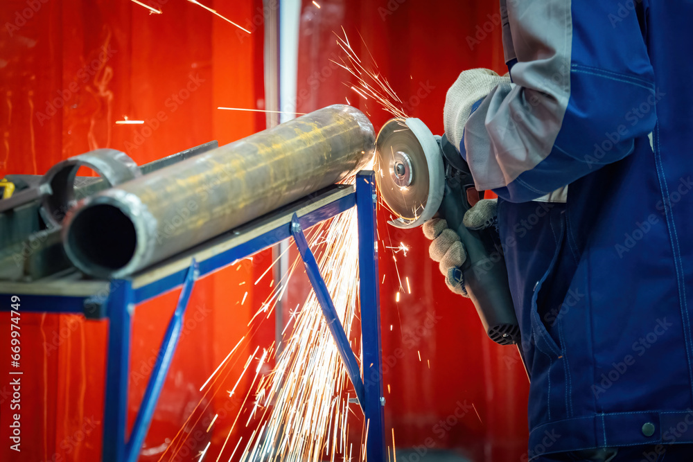 Using hand-held circular saw. Hands of man grinding metal pipe ...