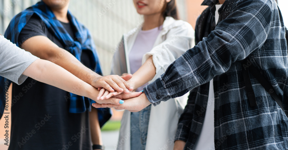 Group of cheerful young Asian entrepreneurs joining hands together to ...