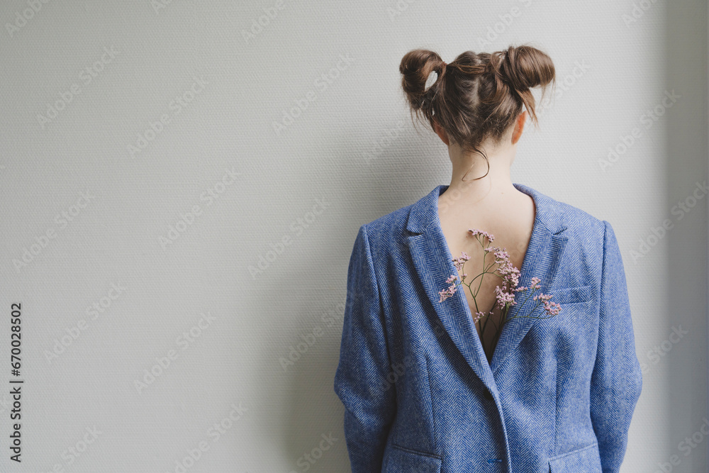 Teenage girl wearing blue blazer backwards with flowers on her back ...