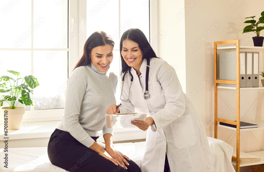 Happy doctor and patient looking at good results after medical tests at ...