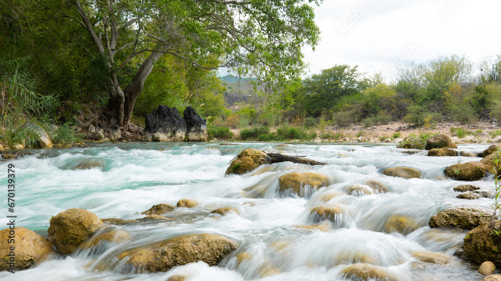 Hermoso rio de aguas azuladas que corre entre las rocas Stock Photo ...