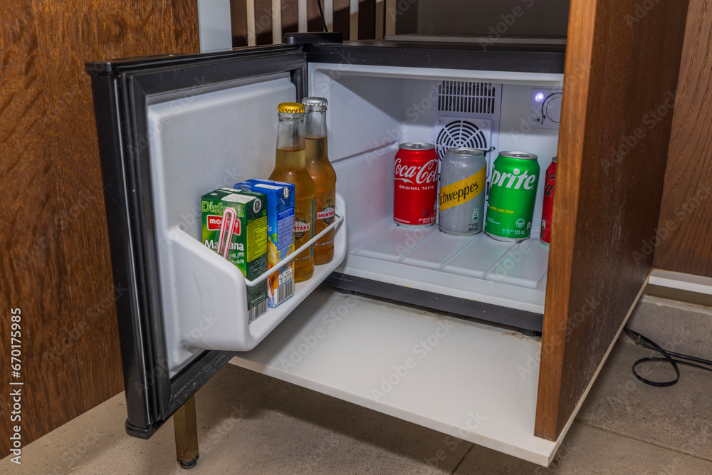Close-up view of open minibar in hotel room, stocked with variety of ...