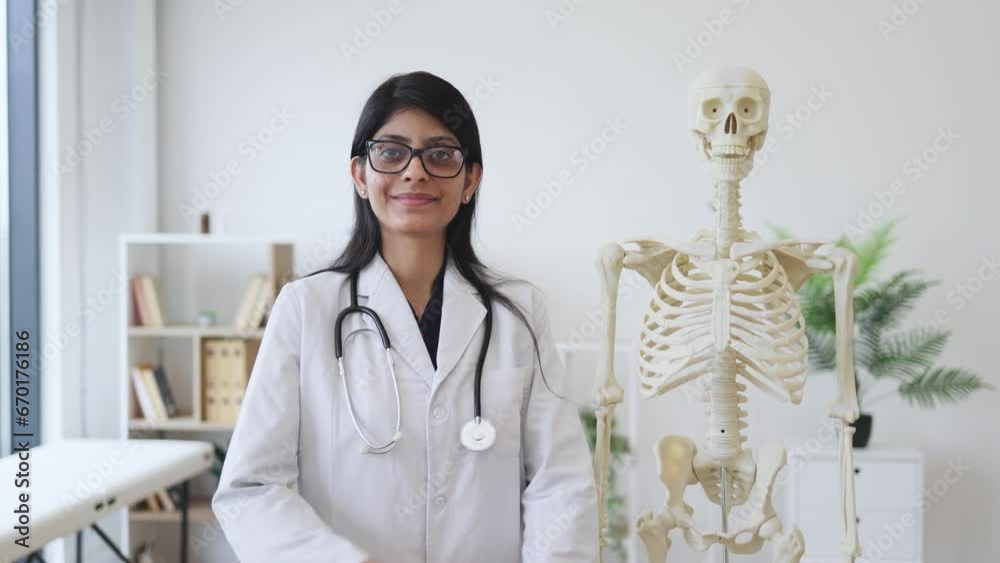 Front view of lady physician wearing hospital gown and goggles standing ...