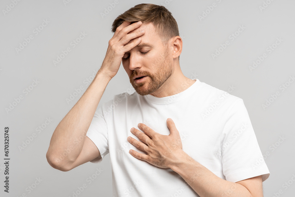 Unhealthy overwhelmed man with unhappy expression covered forehead hand ...