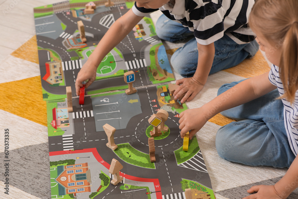 Little children playing with set of wooden road signs and toy cars ...
