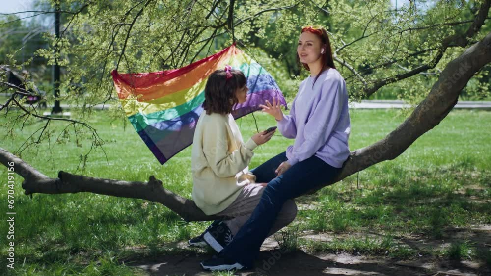 In front of the camera lgbt lady with short hair holding the lgbt flag ...