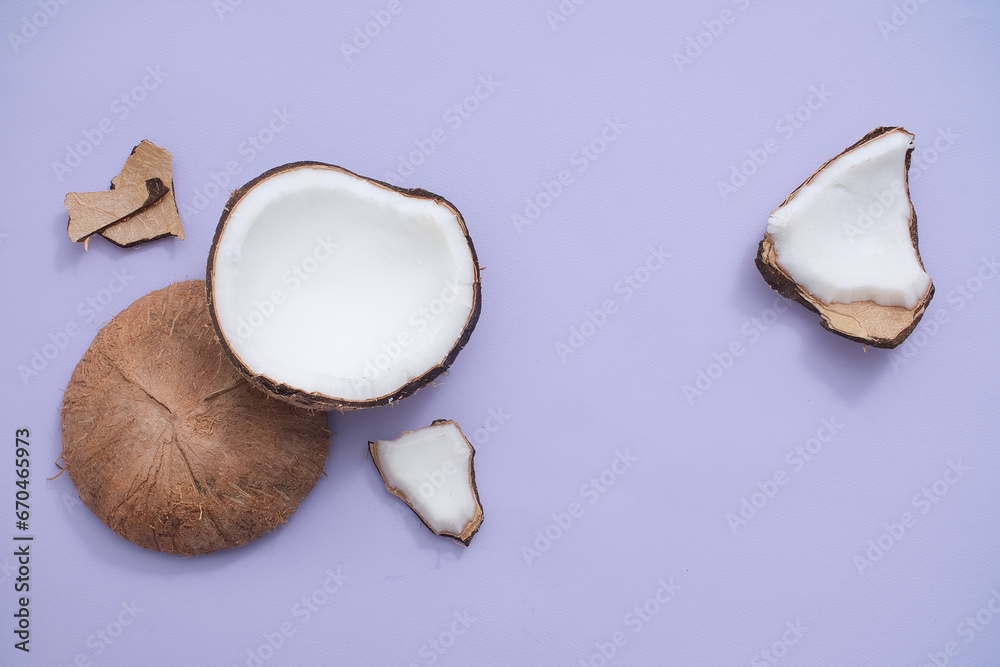 On a minimalist pastel purple background, fresh coconuts are displayed ...