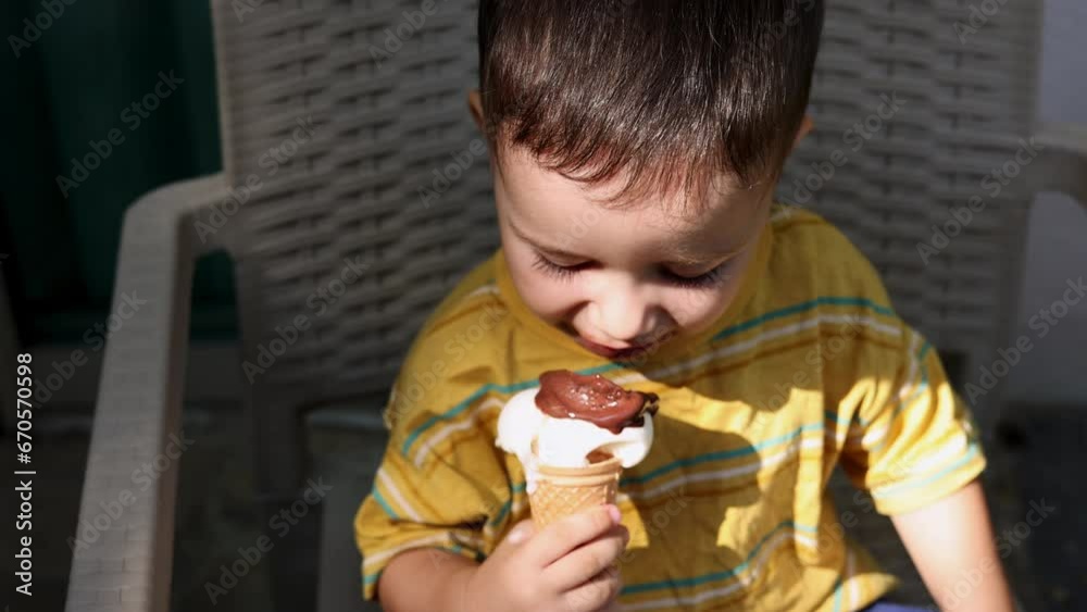 kid boy and baby eating ice cream in cone sitting on chair outdoor ...