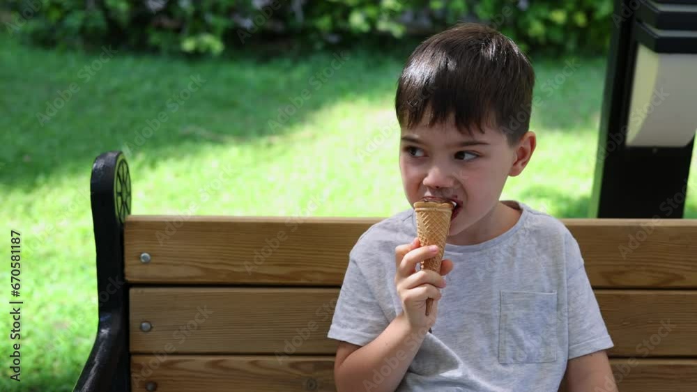 kid boy and baby eating ice cream in cone sitting on chair outdoor ...