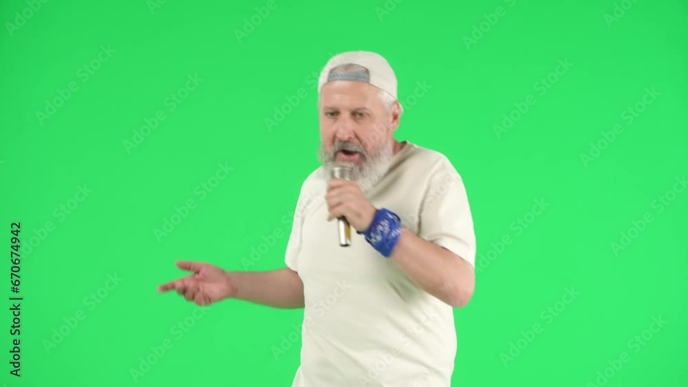 Portrait of senior hipster on Chroma key green screen, old man singing ...