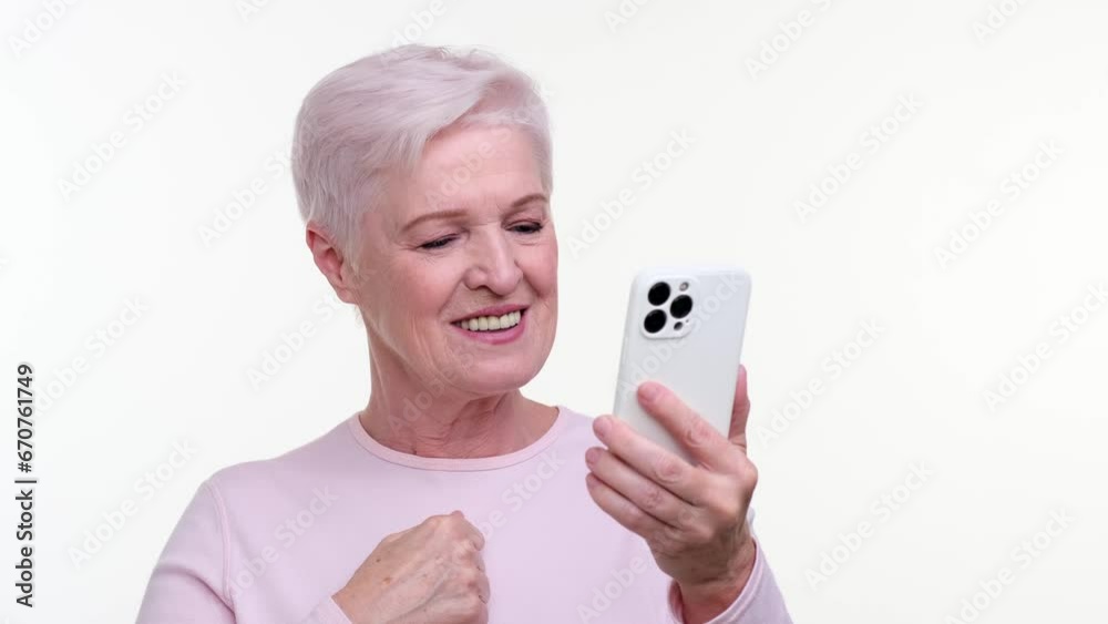 Against a clean white backdrop, a woman engages in a lively video call ...