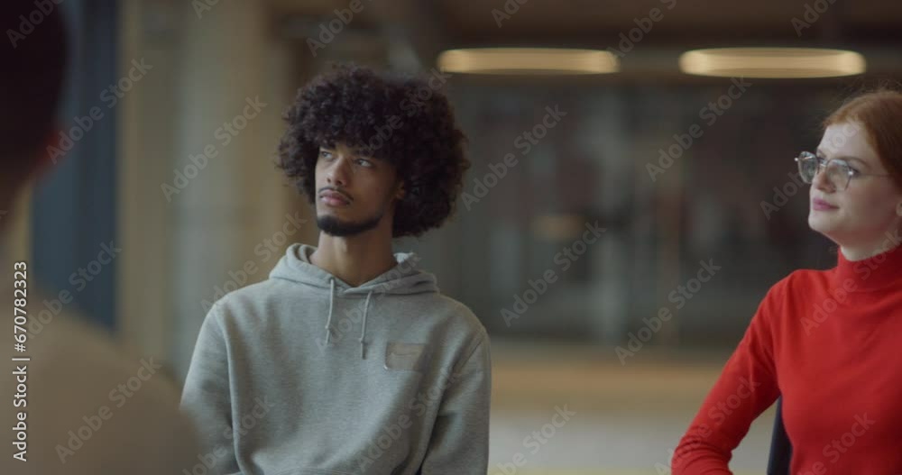 A diverse group of entrepreneurs engages in a dynamic business meeting within a modern office ...