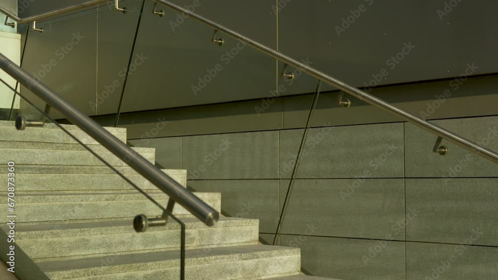 A close-up view of a staircase with light-colored stone steps. On both ...