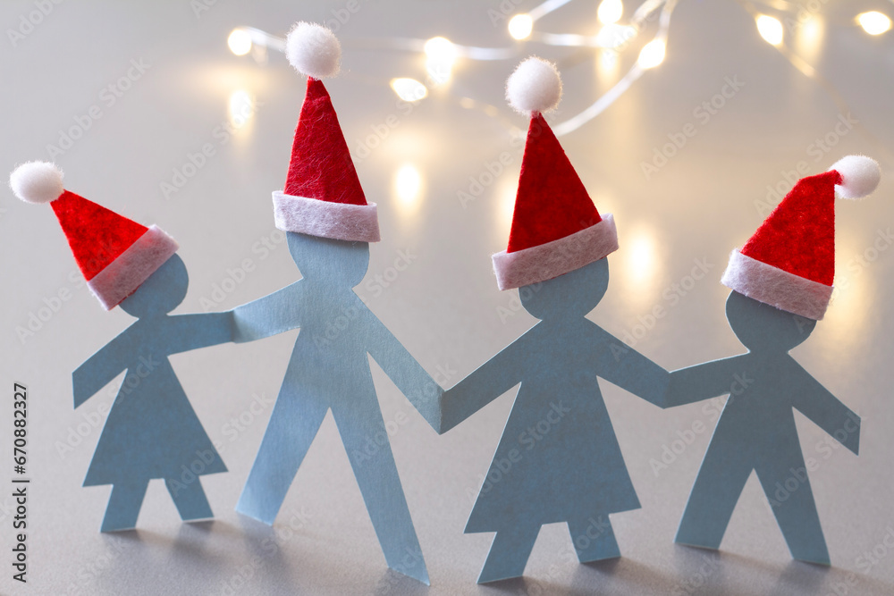 Family of paper people holding hands in Santa Claus hats, family ...