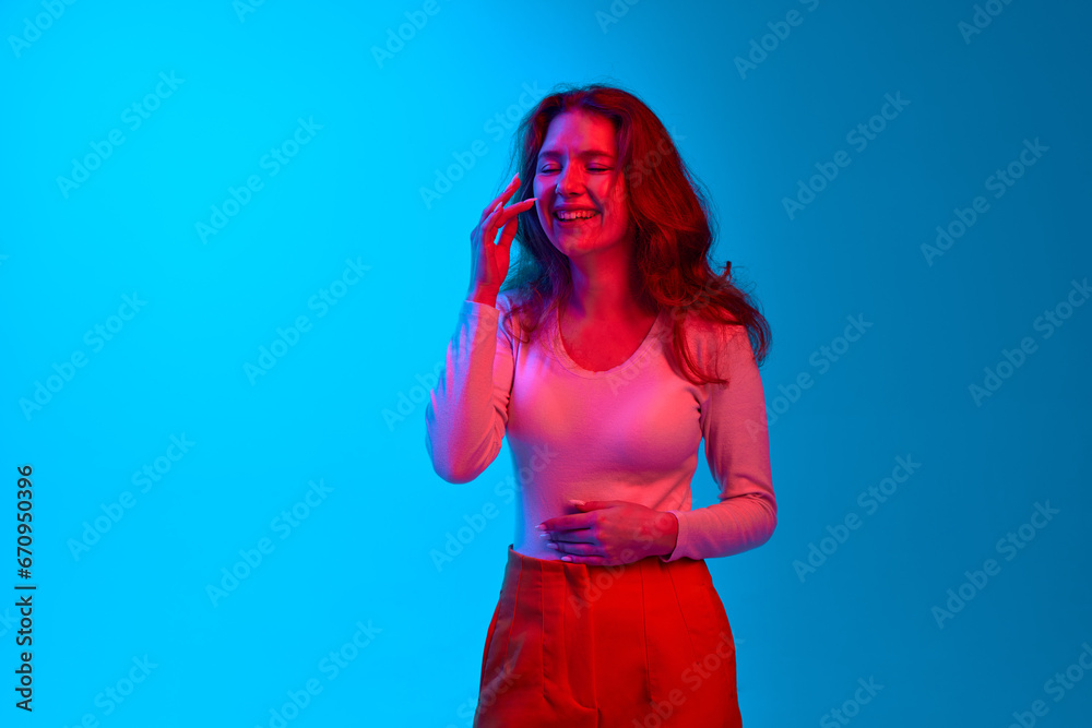 Beautiful young girl cheerfully smiling and laughing against blue ...