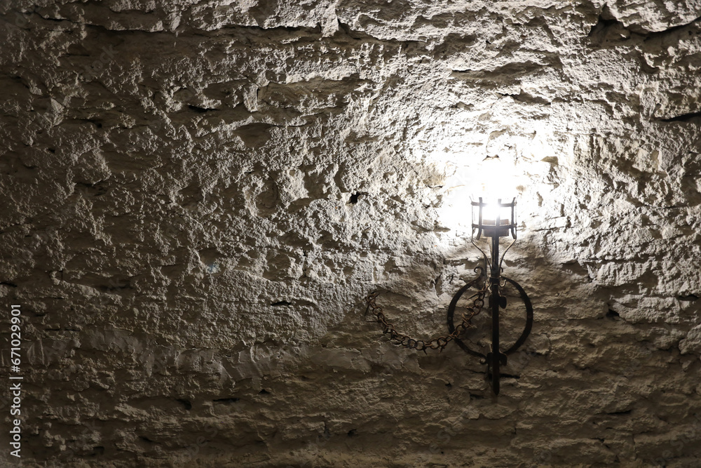 Lighted medieval castle torch hanging on a stone wall, vintage objects ...