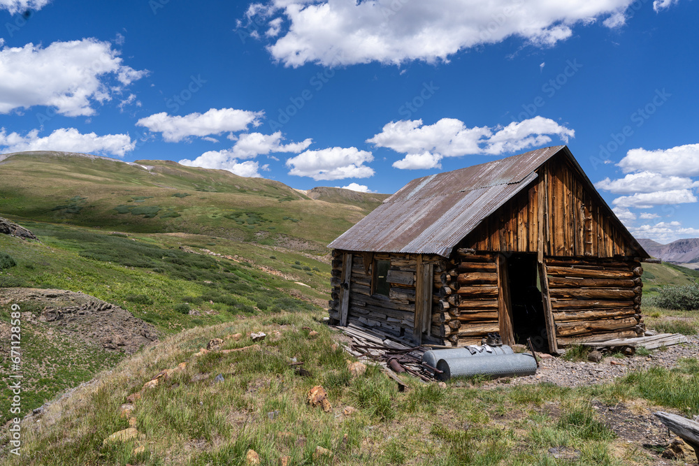 A log cabin with a metal roof at an abandoned gold and silver mine site ...