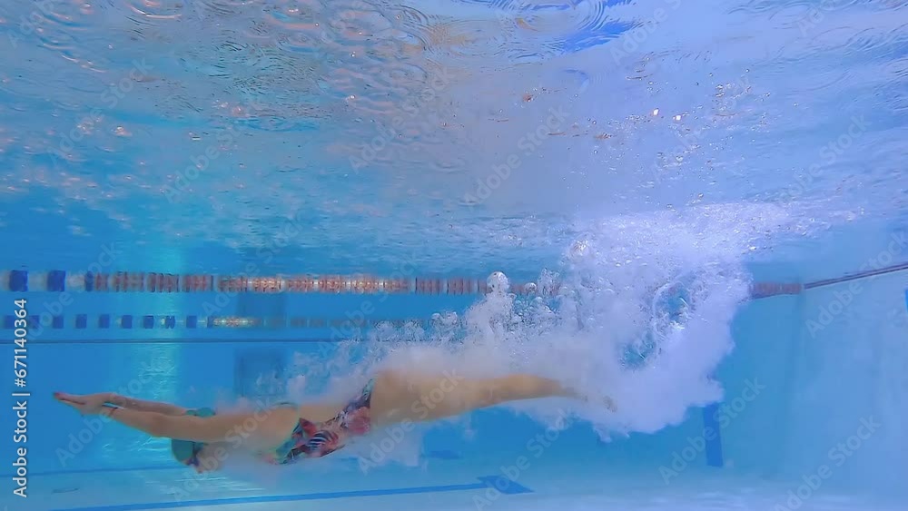 Woman athlete swims underwater in the pool. Slow motion of a female ...