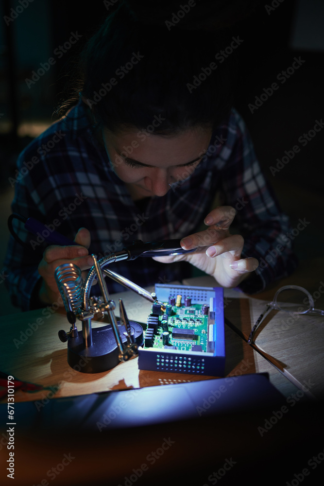 Woman, computer motherboard and night with soldering iron ...