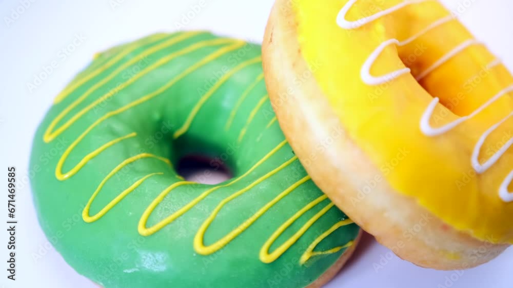 Close up donuts with green and yellow glazing rotate light surface with ...