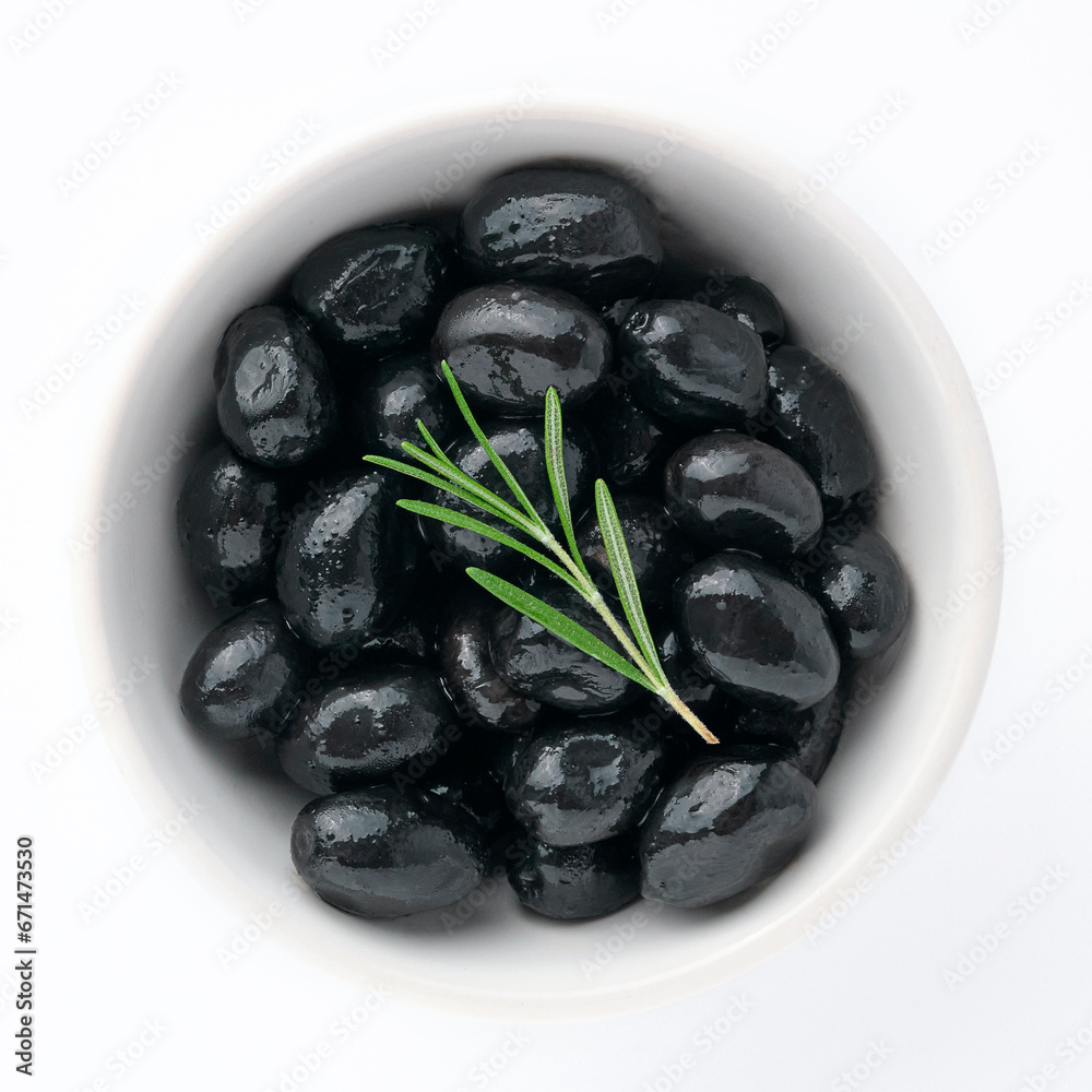 Delicious black olives in plate with olive tree sprig decoration ...