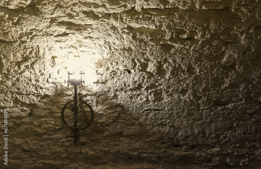 Lighted medieval castle torch hanging on a stone wall, vintage objects ...